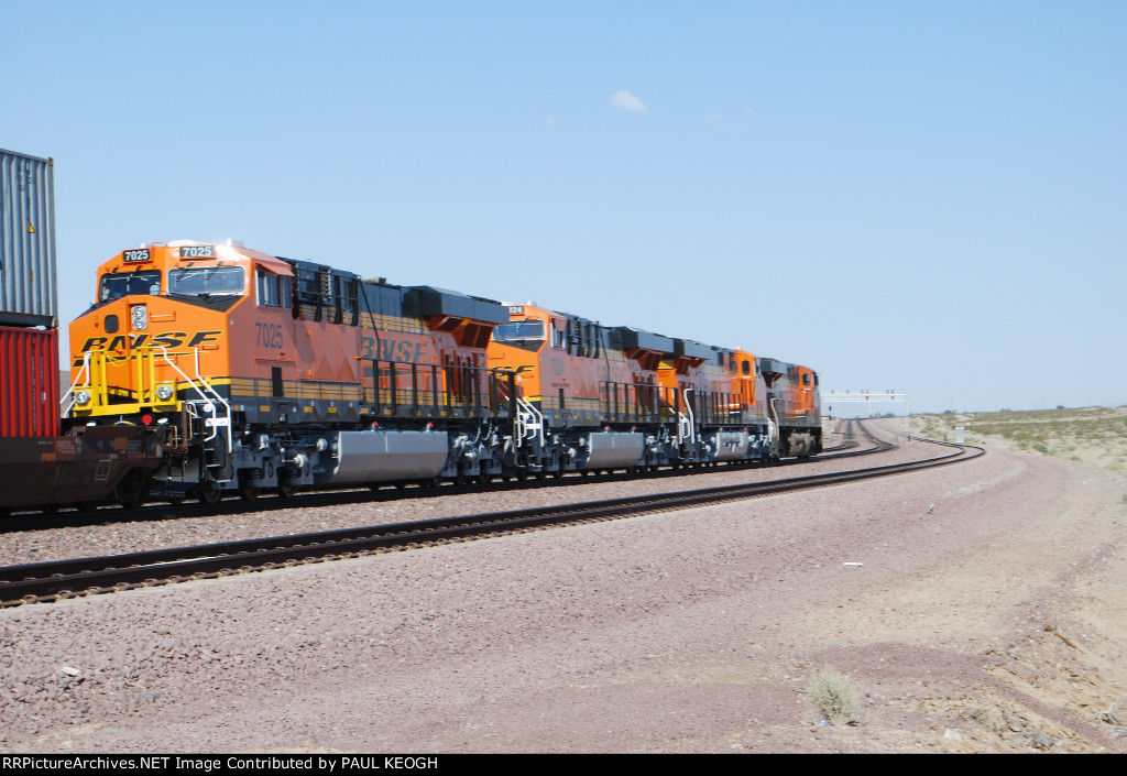 BNSF 7435,BNSF 7027, BNSF 7024 , and BNSF 7025 make the turn towards Daggett, Ca as they lead ...